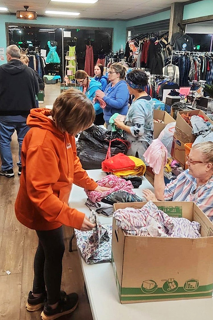 Treasure hunting in action! Shoppers and volunteers sort through freshly unpacked donations, each box potentially hiding someone's next favorite find.