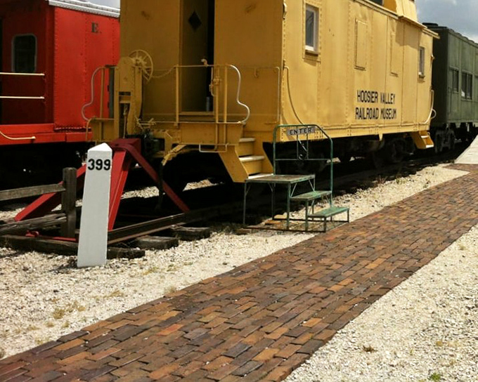 The cheerful yellow caboose #399 sits proudly alongside its red companion, a colorful reminder of when these "crummies" served as mobile offices for hardworking railroad crews.
