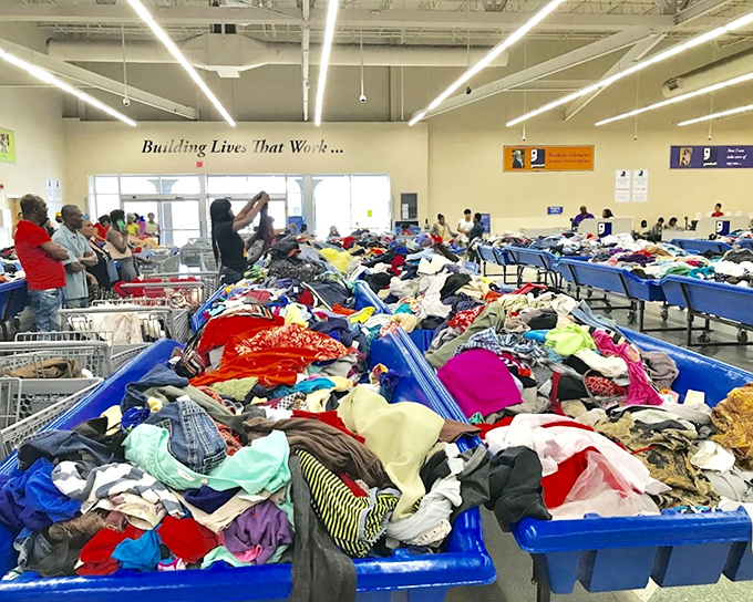 Treasure hunters in their natural habitat. The blue bins become oceans of possibility where yesterday's fashion finds new admirers.