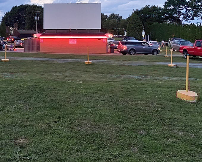The concession stand glows like a ruby in the twilight, promising popcorn and memories in equal measure.