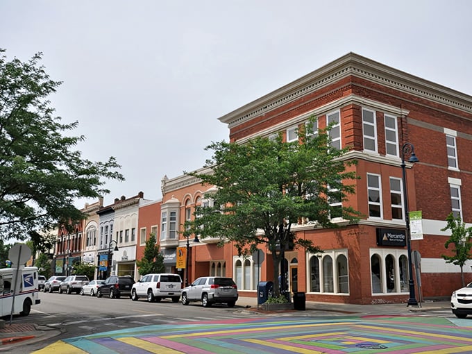 Historic brick buildings stand like patient guardians of small-town charm, while the rainbow intersection below invites both feet and imagination to wander.