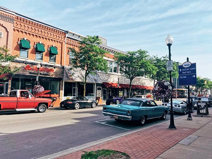 Classic cars cruise past historic brick buildings where charm meets surprisingly reasonable real estate prices.