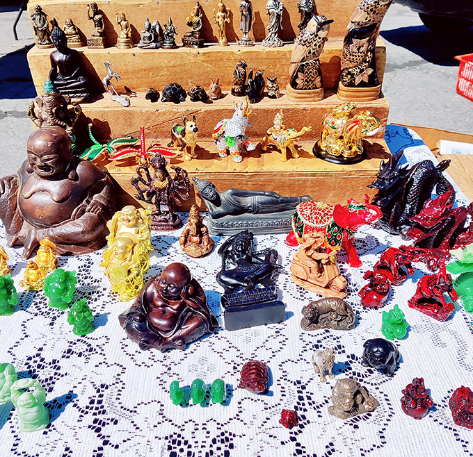 Tiny deities and mystical figurines stand guard over this vendor's table, silently promising good fortune to their future owners.