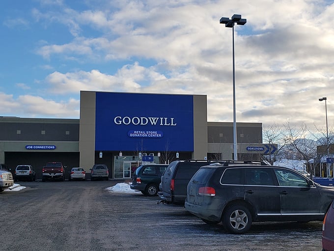 The blue Goodwill sign stands against an Alaskan sky, a beacon of bargain hope in a land where new retail comes with a hefty "shipping to the Last Frontier" tax.
