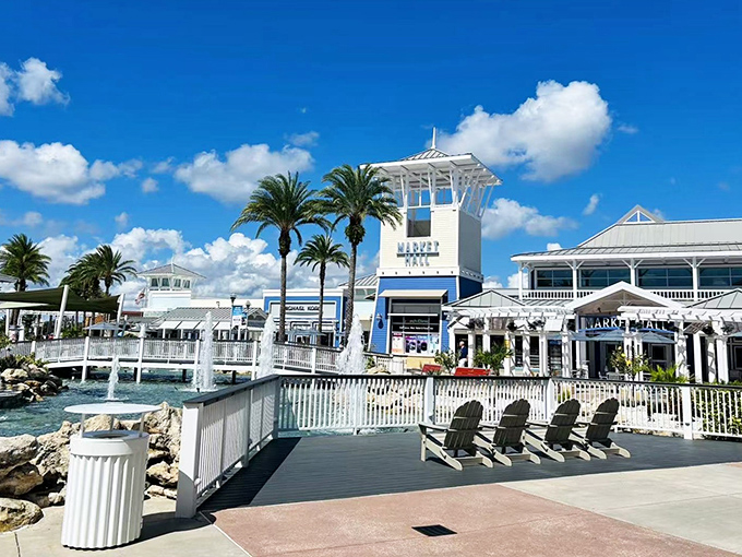 Palm trees frame the iconic blue and white tower, where Florida sunshine meets discount designer labels under perfect puffy clouds.