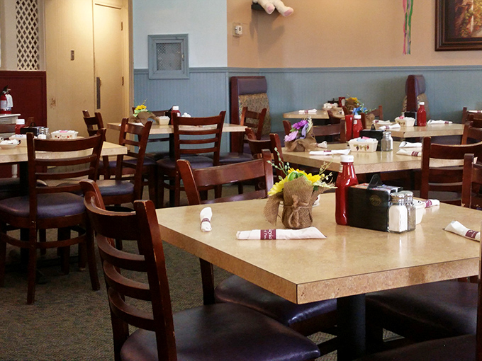 Simple wooden chairs, laminate tables, and fresh flowers create that perfect "come as you are" atmosphere where breakfast dreams come true.