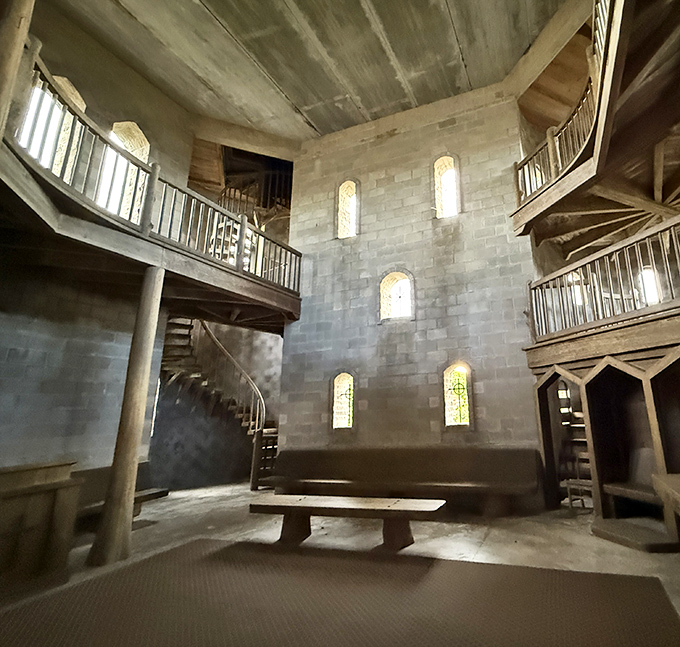 Step inside to discover a soaring cathedral-like interior where wooden balconies and stone walls create a space that whispers of ancient monasteries.