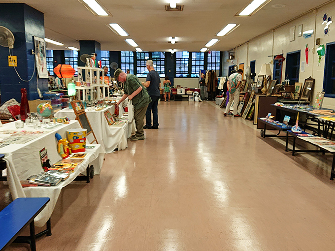 A quiet moment between browsers reveals the bazaar's indoor charm. School hallways transformed into galleries of possibility where conversations between strangers flow naturally.