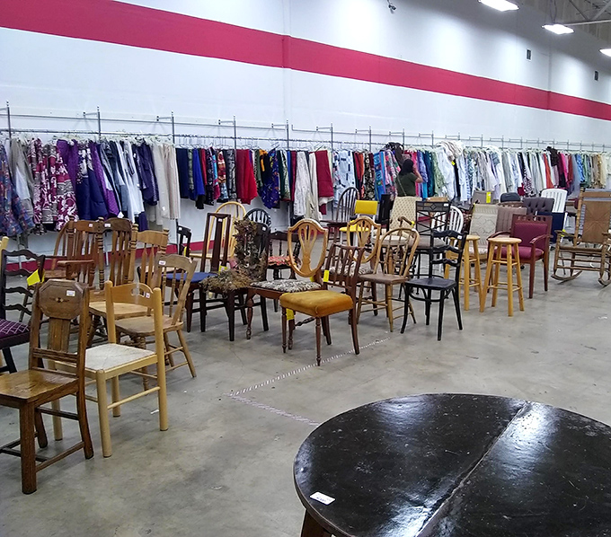 Inside this warehouse of wonders, where chairs and clothes create a symphony of secondhand splendor under those bright, hopeful lights.