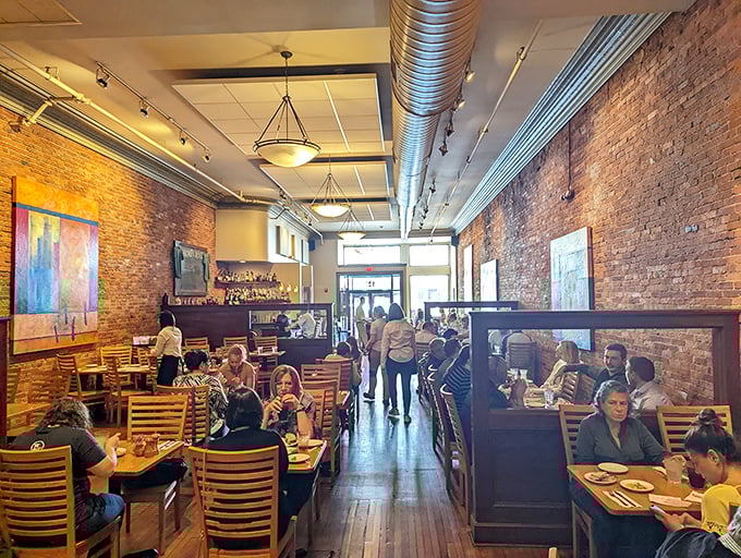 Inside, exposed brick walls and wooden tables create that perfect "third place" atmosphere—not home, not work, just pure dining bliss.