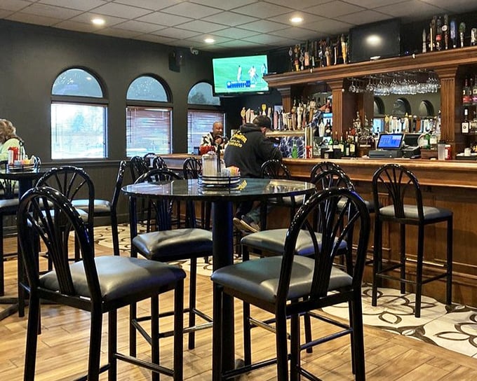 The lounge side offers that perfect blend of neighborhood bar charm and comfortable elegance. Those high-backed chairs practically whisper, "Stay awhile."