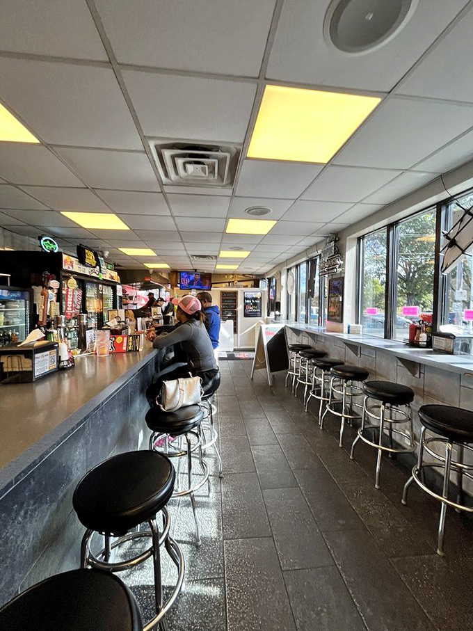 Classic counter seating where strangers become friends, united by the universal language of "pass the napkins, please."