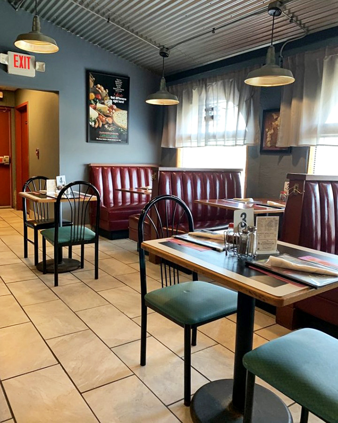 Classic burgundy booths and blue walls create that perfect "neighborhood Italian joint" vibe where comfort begins before the food even arrives.