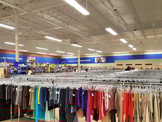 Color-coded clothing racks stretch toward retail infinity. The blue wall's "Brighter Future" motto isn't just decoration&mdash;it's the mission behind every bargain.