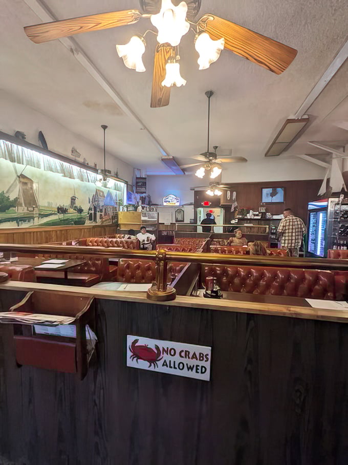 Red vinyl booths and wood paneling create a time capsule where the "NO CRABS ALLOWED" sign applies only to the human variety.