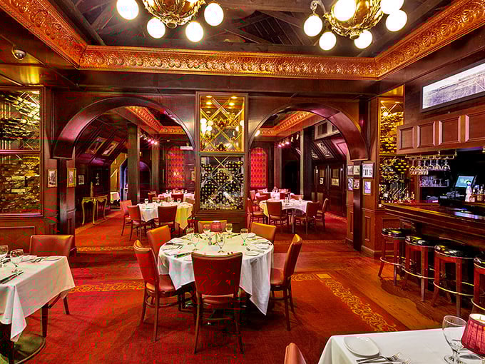 Opulence meets appetite in this dining room where rich wood, elegant arches, and white tablecloths set the stage for meat-centric magic.