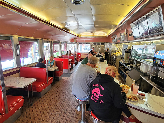 Where conversations flow as smoothly as the coffee. The gleaming counter and cherry-red booths promise a timeless dining experience.