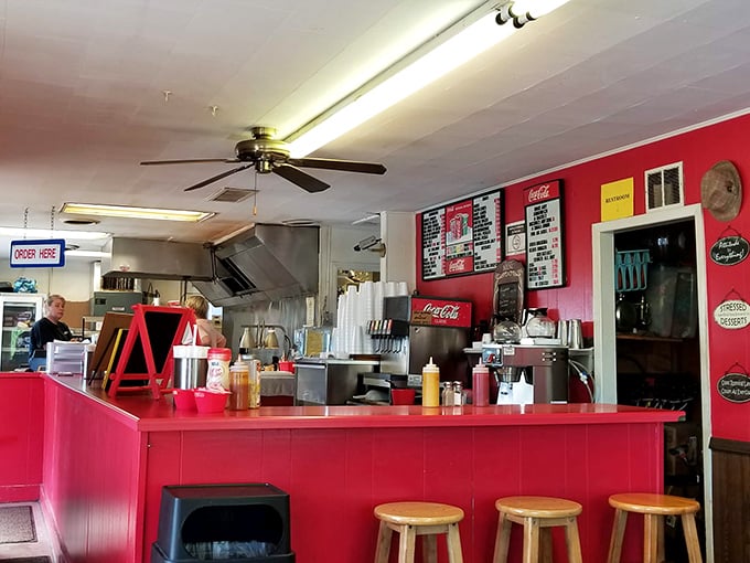 Behind this vibrant red counter, burger magic happens daily. The open kitchen setup lets you witness the sizzle-to-plate journey of your meal.