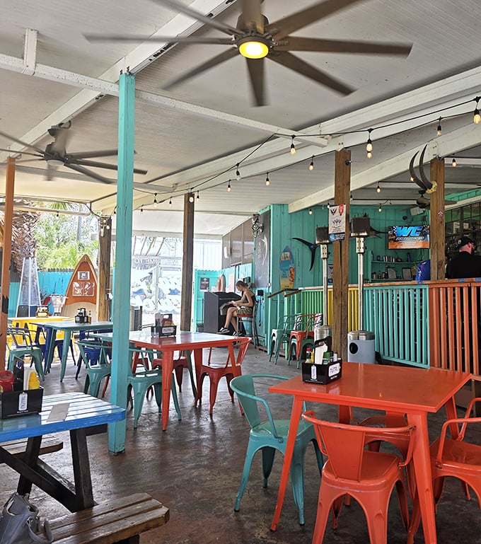 Where Florida's vibrant personality comes to life through turquoise posts and coral-colored tables. The string lights stand ready for when sunset turns happy hour magical.