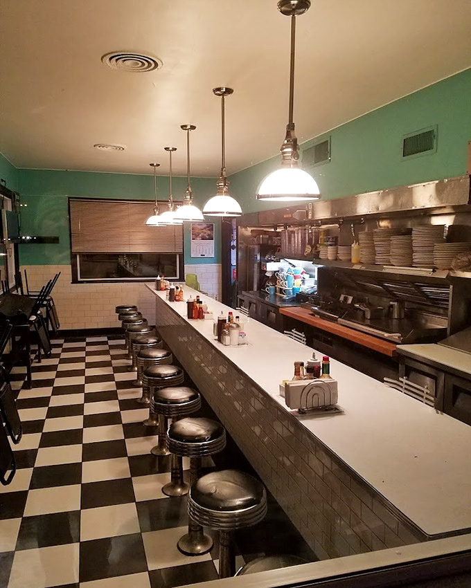 Classic diner perfection: chrome stools, checkered floor, and mint green walls create the stage where breakfast dreams come true. Hemingway would approve of this clean, well-lighted place.