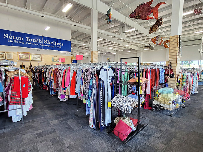 Colorful clothing racks beneath whimsical hanging fish&mdash;Seton Youth Shelters' partnership turns your shopping spree into community support.