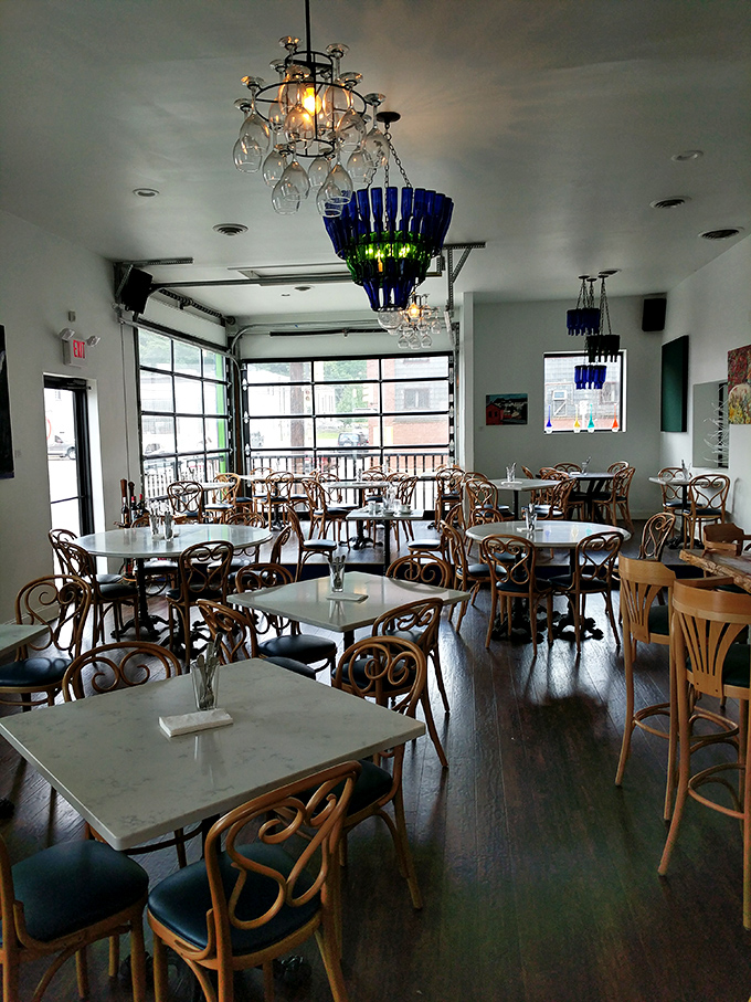 Blue bottle chandeliers cast a warm glow over marble-topped tables, creating that perfect "treat yourself but still feel comfortable" dining atmosphere.