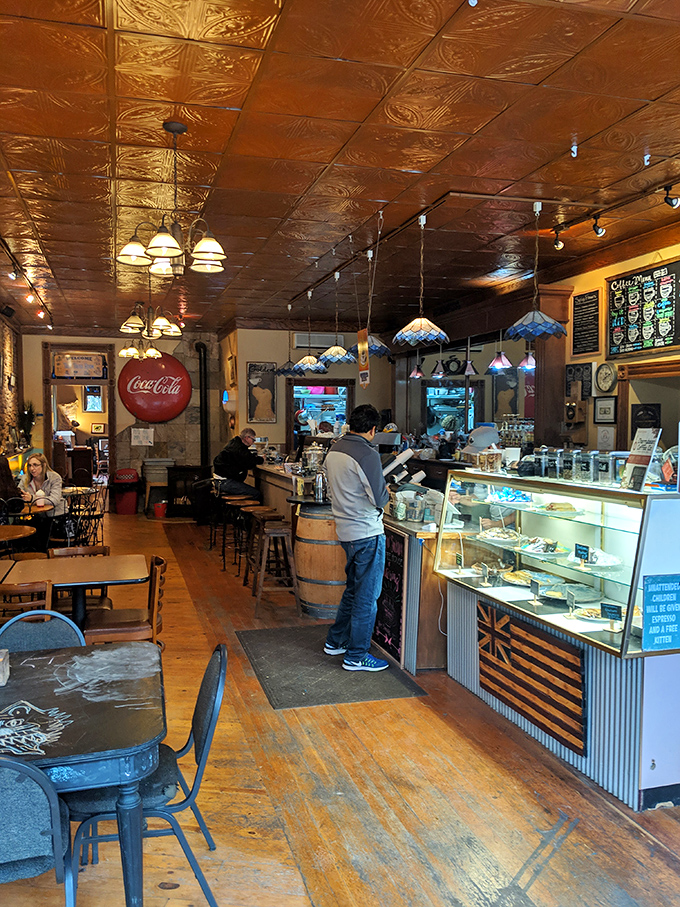 Beneath copper-hued tin ceilings, Tiffany-style lamps cast a warm glow over wooden floors that have hosted countless caffeine-fueled conversations.