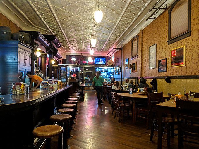 Step inside and the pressed tin ceiling, warm wood tones, and vintage bar stools instantly transport you to a simpler time when conversations mattered more than WiFi passwords.