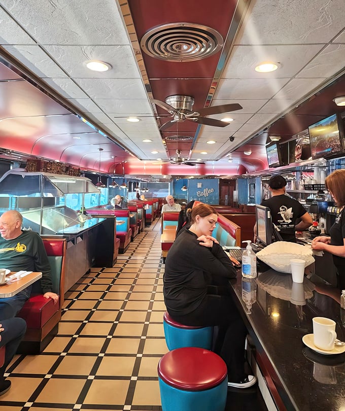 Inside, the quintessential diner experience unfolds with checkered floors, red vinyl booths, and the gentle hum of conversation.