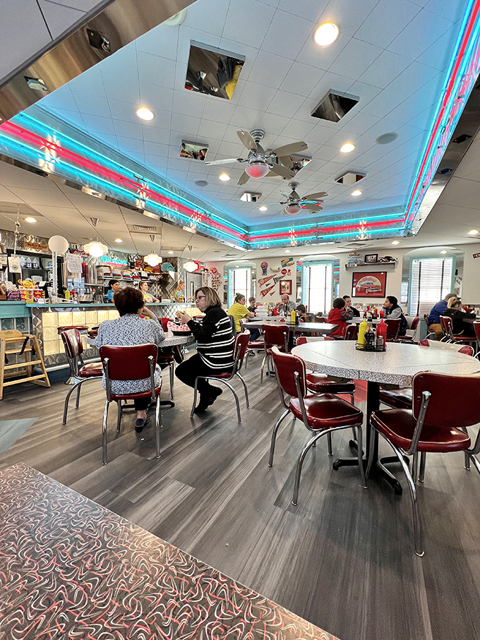 Neon dreams come true under that signature turquoise and pink ceiling trim. The diner hums with conversation and the promise of comfort food.