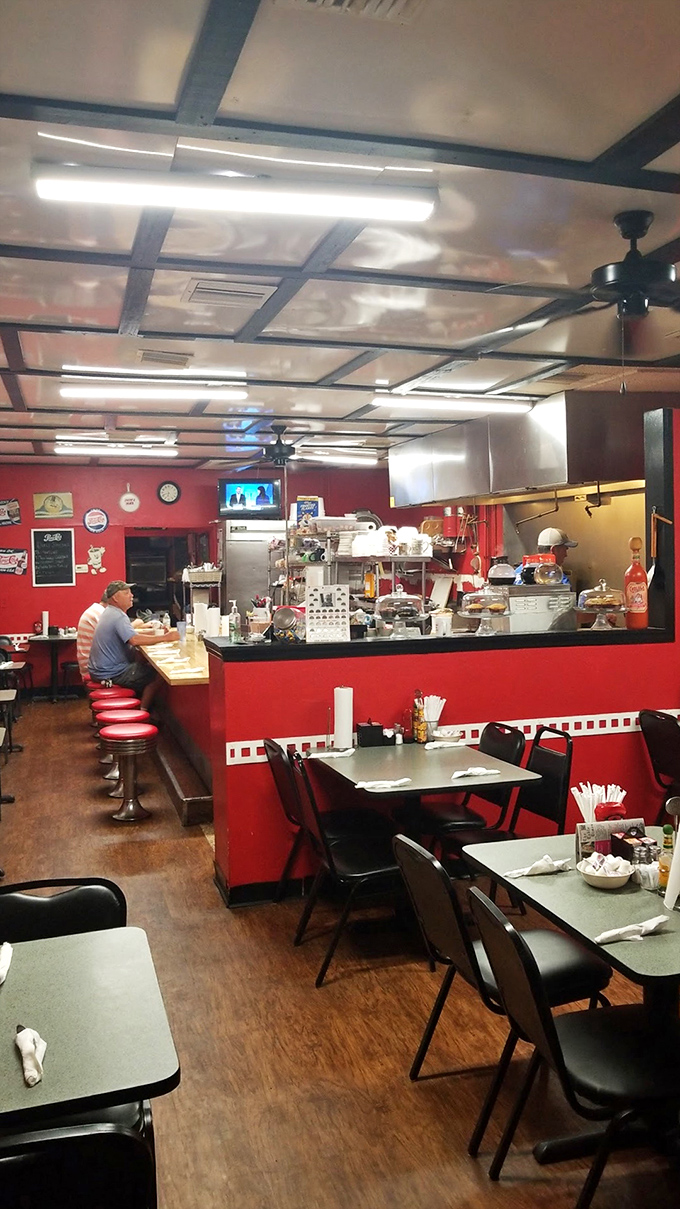Classic diner ambiance with vibrant red walls and counter seating that whispers, "Stay awhile, the coffee's always fresh."
