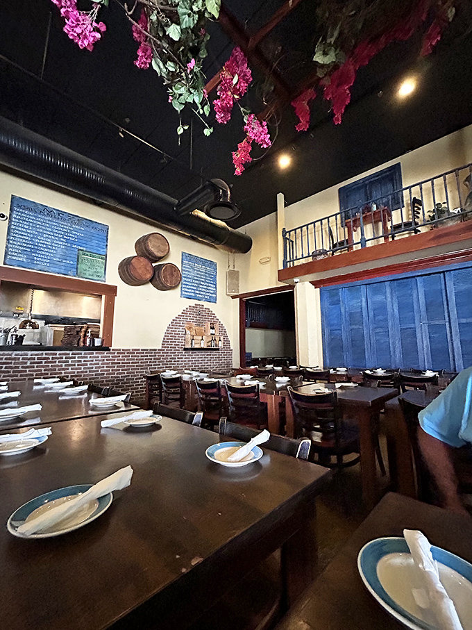 Pink bougainvillea cascades from the ceiling like a Greek island dream, while wooden barrels hint at the wine-soaked festivities to come. Santorini meets Orlando in the best possible way.