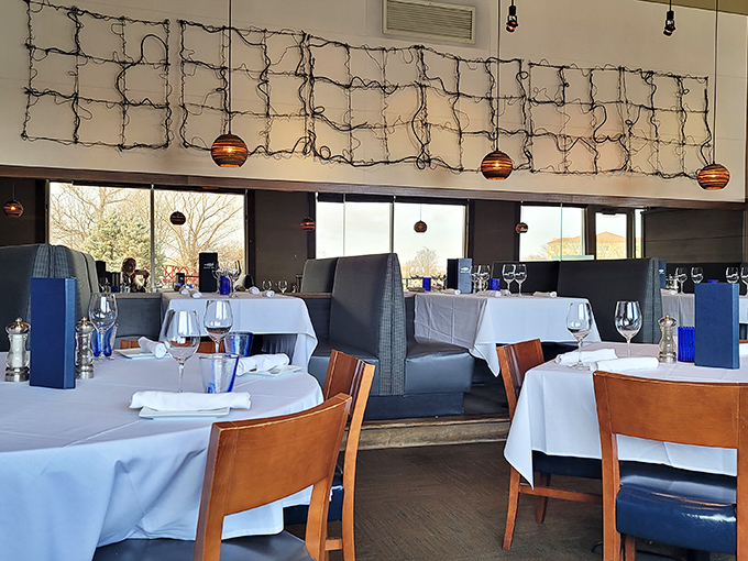 The dining room balances sophistication with comfort&mdash;crisp white tablecloths and artistic wire installations set the stage for seafood magic.