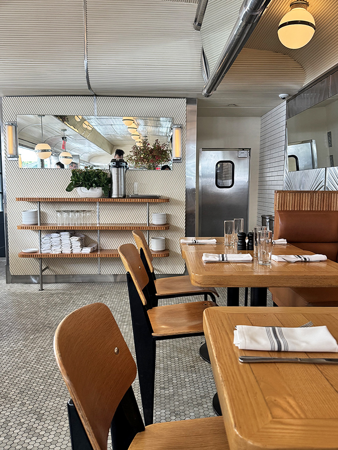 Inside, mid-century modern meets contemporary cool with hexagonal tile floors, wooden tables, and open shelving that strikes the perfect balance between nostalgia and now.