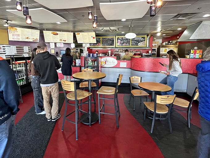 Inside Ruby K's, the red floor and wooden tables create a no-nonsense atmosphere where serious bagel business happens daily. 