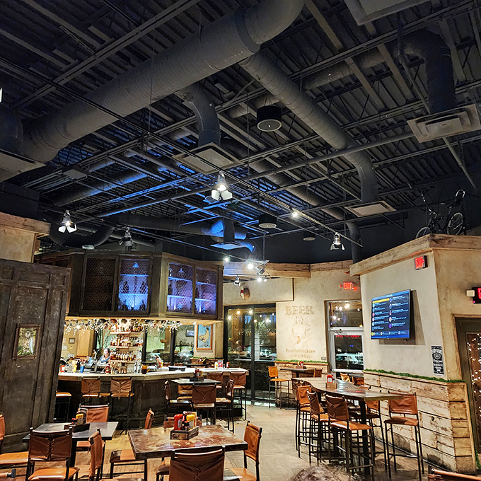Industrial-chic meets comfort in this inviting space where exposed ductwork and blue lighting create the perfect backdrop for serious burger business.