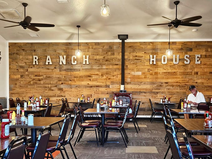 The warm wood accent wall says it all: this is a place where comfort reigns supreme and ceiling fans keep the conversation as easy as the atmosphere.