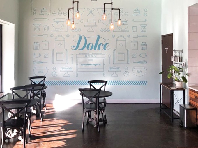 Clean lines, whimsical wall art, and those Edison bulbs—this isn't just a bakery, it's where comfort meets style in the sweetest possible way.