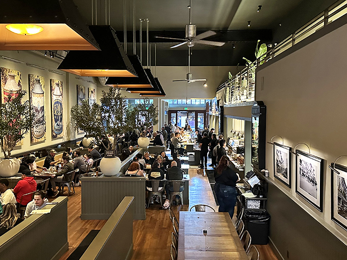 Inside, the bustling dining room hums with conversation and clinking glasses. The warm wood tones and industrial touches create that "I've just discovered my new favorite place" feeling.