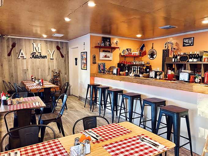 Step inside to discover warm orange walls, rustic wood accents, and those quintessential red-checkered tablecloths that whisper "authentic French bistro."