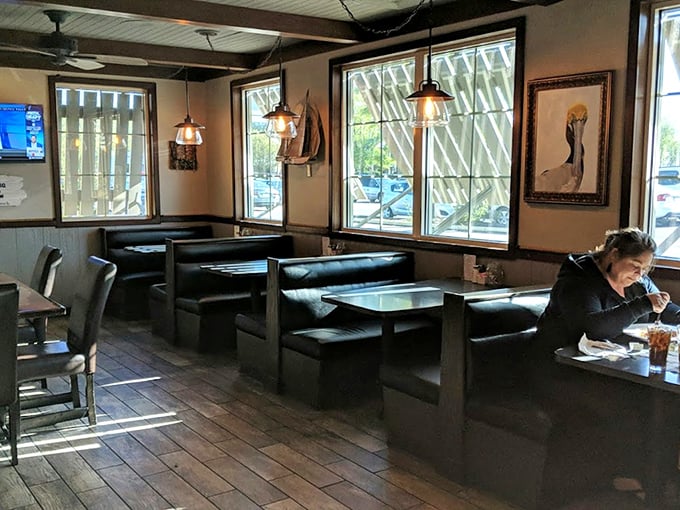 Dark wood booths bathed in natural light create that perfect "I could stay here all afternoon" vibe. Nautical artwork completes the coastal retreat feeling.