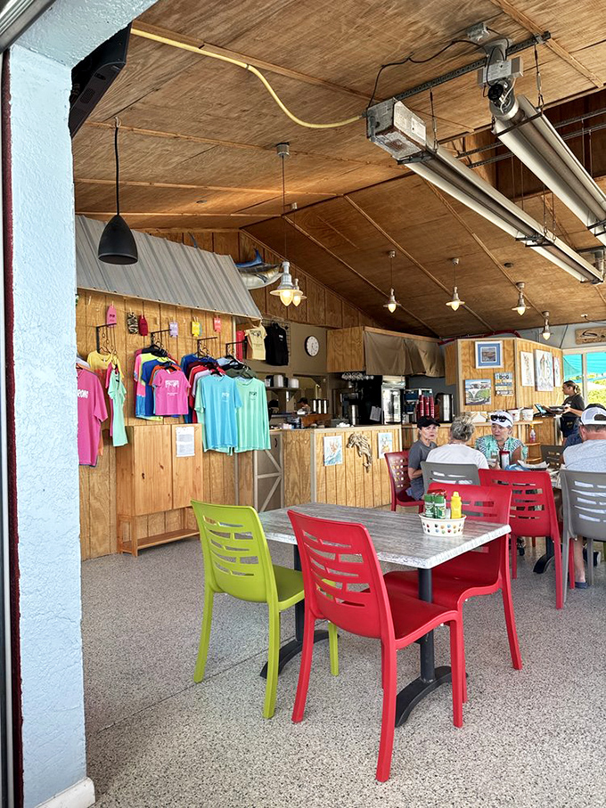 Inside, colorful chairs pop against wooden walls—nautical without trying too hard, like the best beach bars always are.