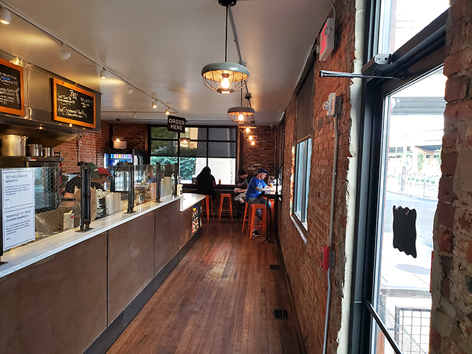 Step inside to exposed brick, warm wood floors, and the tantalizing aroma of fried chicken that makes waiting in this narrow hallway feel like Christmas morning anticipation.