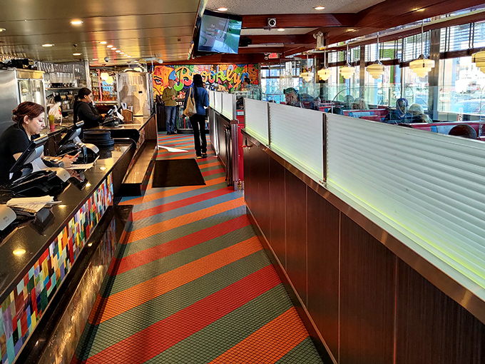 The colorful, striped carpet leads you through a diner wonderland where every booth feels like the best seat in the house.