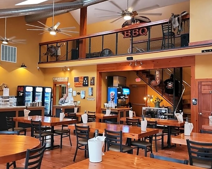 The golden walls and wooden tables say "casual," but the loft-style second level whispers "we're serious about barbecue" in a way that makes you listen.