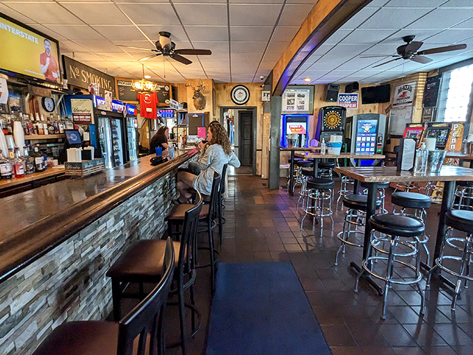 The classic bar setup&mdash;wood paneling, dartboard in the corner, ceiling fans spinning lazily overhead&mdash;creates that perfect "I'm exactly where I need to be" feeling.