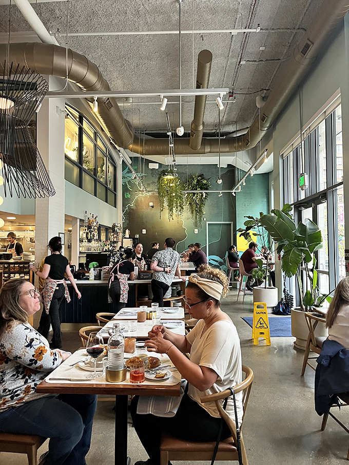 Industrial chic meets Italian warmth in this airy space, where hanging plants soften concrete ceilings and every table feels like the best seat in the house.