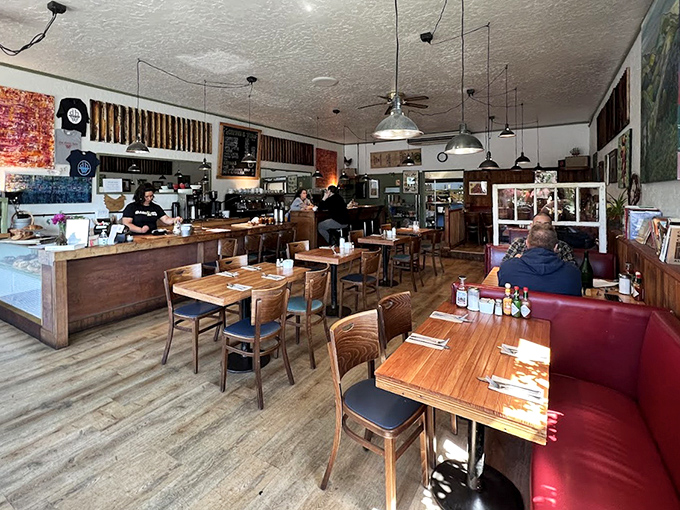 Morning sunshine streams through windows illuminating wooden tables where breakfast dreams come true. The red banquette practically begs you to settle in for the long haul.