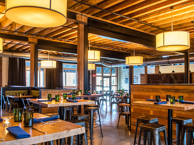 Industrial chic meets cozy comfort in this thoughtfully designed space where wooden beams and warm lighting create the perfect backdrop for food-induced happiness.