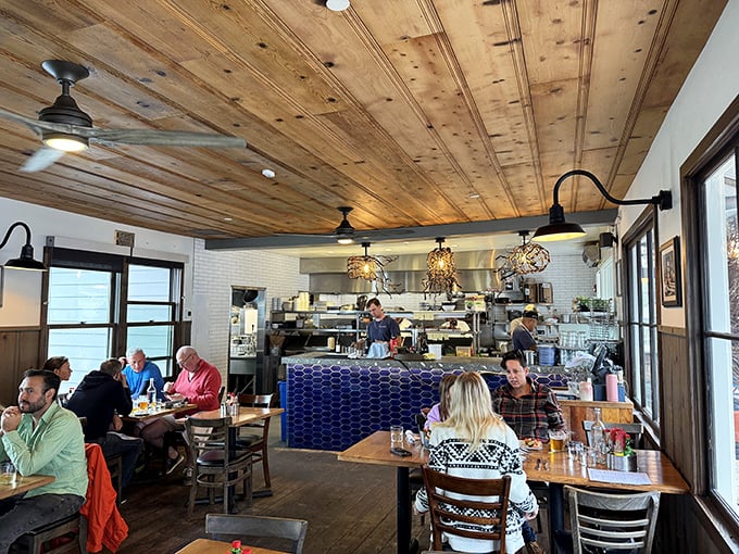 Rustic wooden ceilings meet modern blue tile in this dining room where conversations pause only for the next delicious bite.